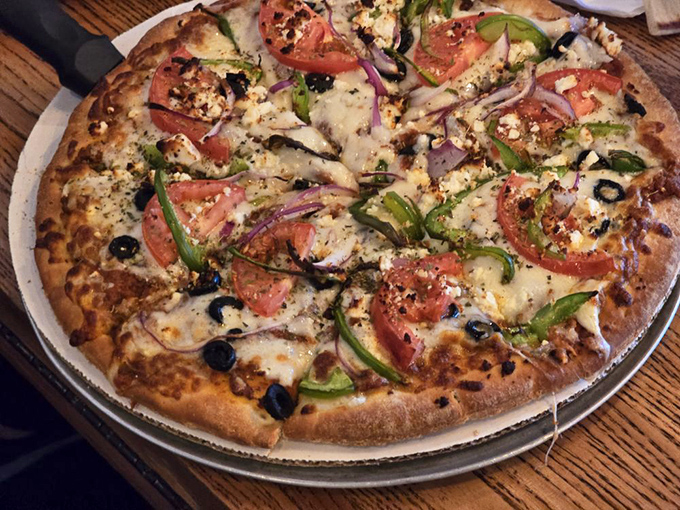 Greek pizza that bridges cultural divides&mdash;a crispy crust playground where feta, olives, and fresh vegetables hold their Mediterranean summit meeting.