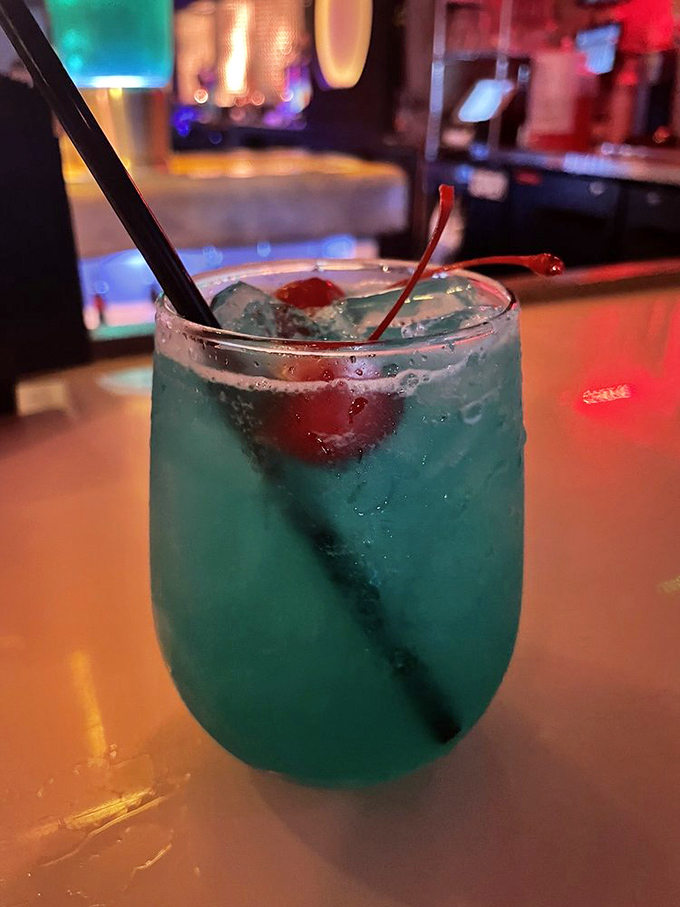 Electric blue with a cherry garnish, this cocktail doesn't just quench your thirst—it transports you to Gotham City with every sip.
