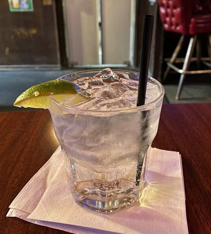 A pristine gin and tonic, garnished with lime, awaits its destiny as the perfect companion to your steak&mdash;simple, elegant, and utterly necessary.