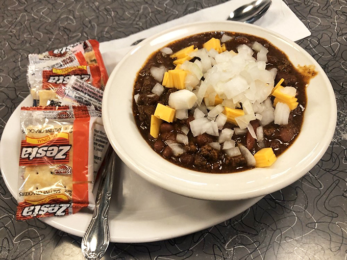 This isn't just chili&mdash;it's a warm hug in a bowl, topped with the holy trinity of diced onions, cheese, and crackers on standby.