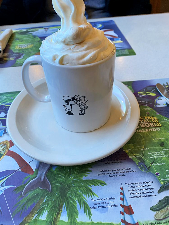 That's not just hot chocolate – it's a mountain of whipped cream with a warm chocolate lake underneath, served in their signature mug.