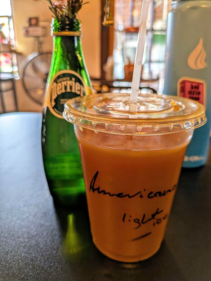 "Americano light" scribbled on the cup like a love note. This amber elixir sits ready to transform your afternoon slump into productive bliss.
