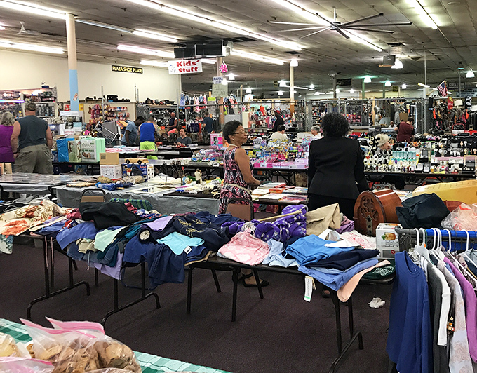A sea of fabrics and possibilities spreads across tables where shoppers hunt for that perfect piece to complete a wardrobe or home.