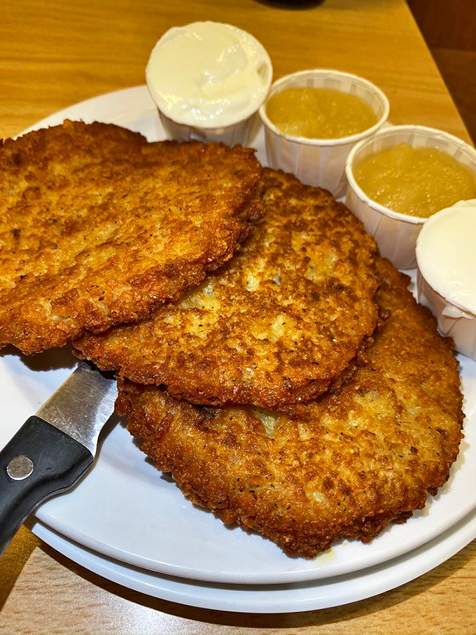 Golden-brown latkes with their crispy edges and tender centers await the perfect topping &ndash; applesauce or sour cream? Why not both?