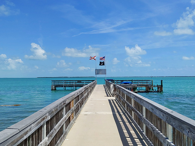 This wooden pier at Lignumvitae Key stretches toward adventure with flags fluttering like nature's invitation to explore further.