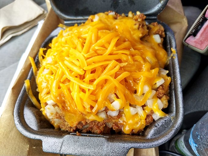 Waffle fries transformed into a cheese-covered landscape of deliciousness that would make any cardiologist nervously clear their throat.