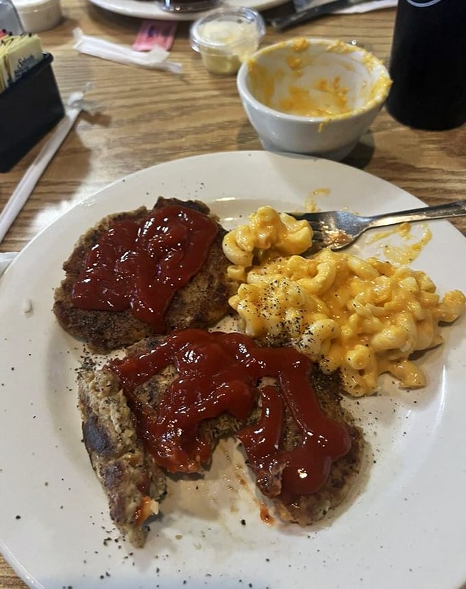 Meatloaf with ketchup glaze alongside mac and cheese that's unapologetically orange. Childhood comfort with grown-up portion sizes.