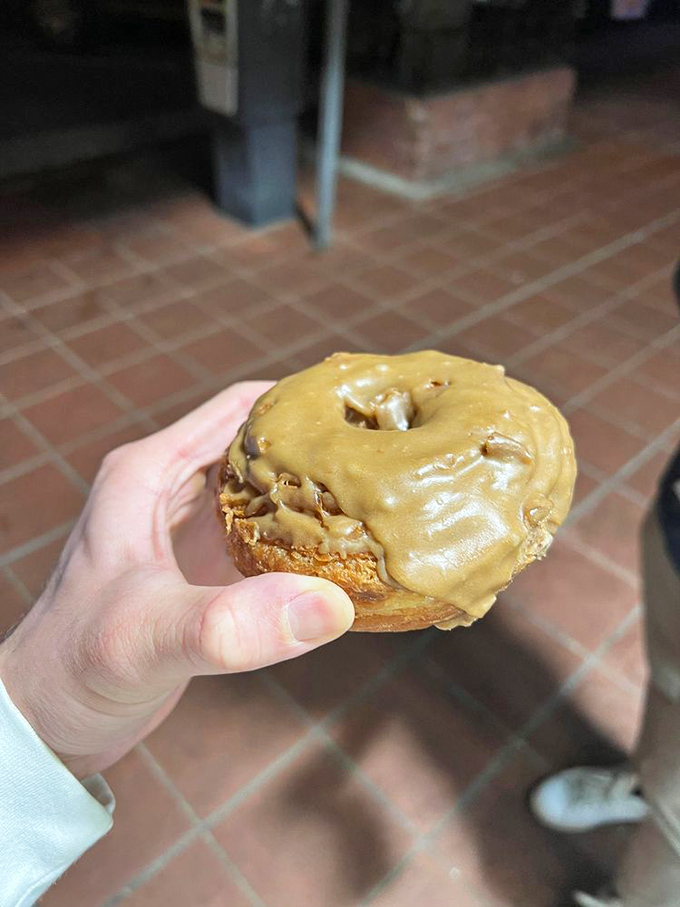 Someone's holding happiness in their hand&mdash;a perfectly glazed maple donut that's about to make their day approximately 300% better.