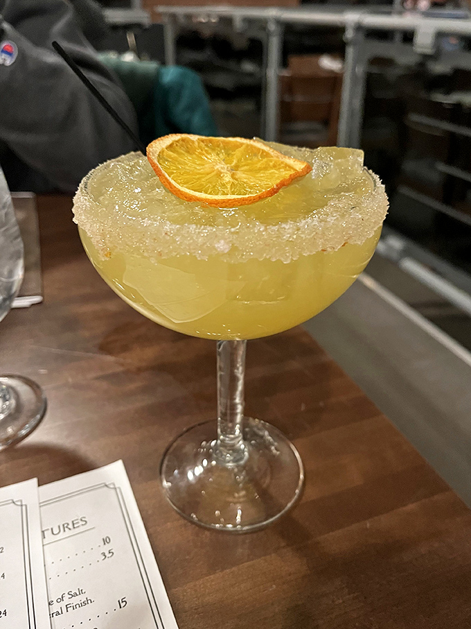 A margarita with a sugar-crusted rim and citrus slice that promises to make dinner conversation flow as smoothly as it does.