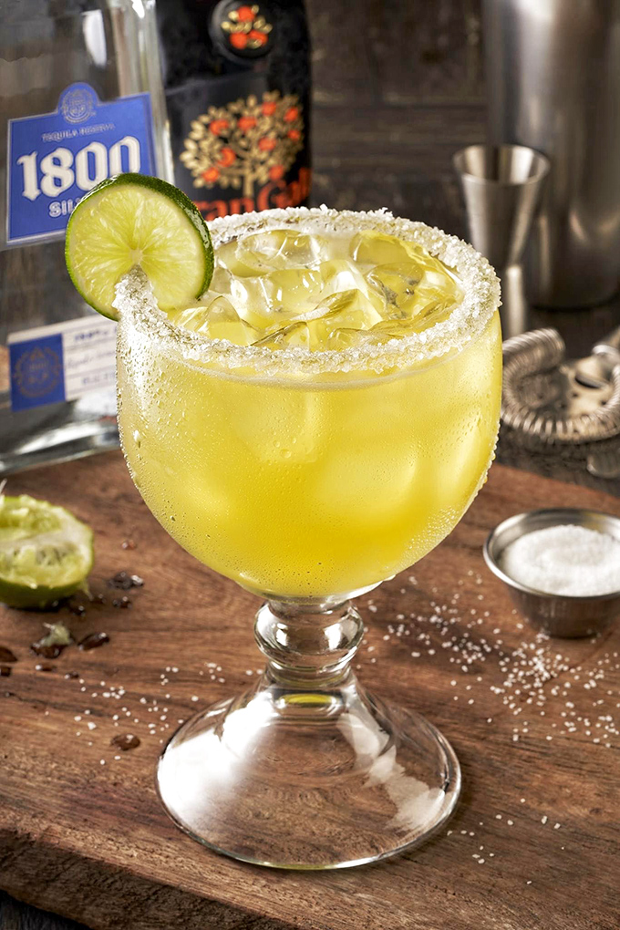 The margarita sits regally on its wooden throne, salt-rimmed and lime-crowned, promising to turn your "I'll just have one" into a delightful series of fibs.