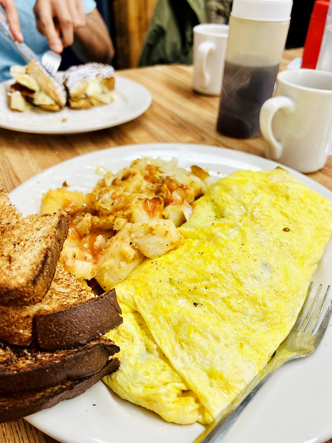Sunshine on a plate! This fluffy yellow omelet surrounded by home fries is the breakfast equivalent of winning the morning lottery.