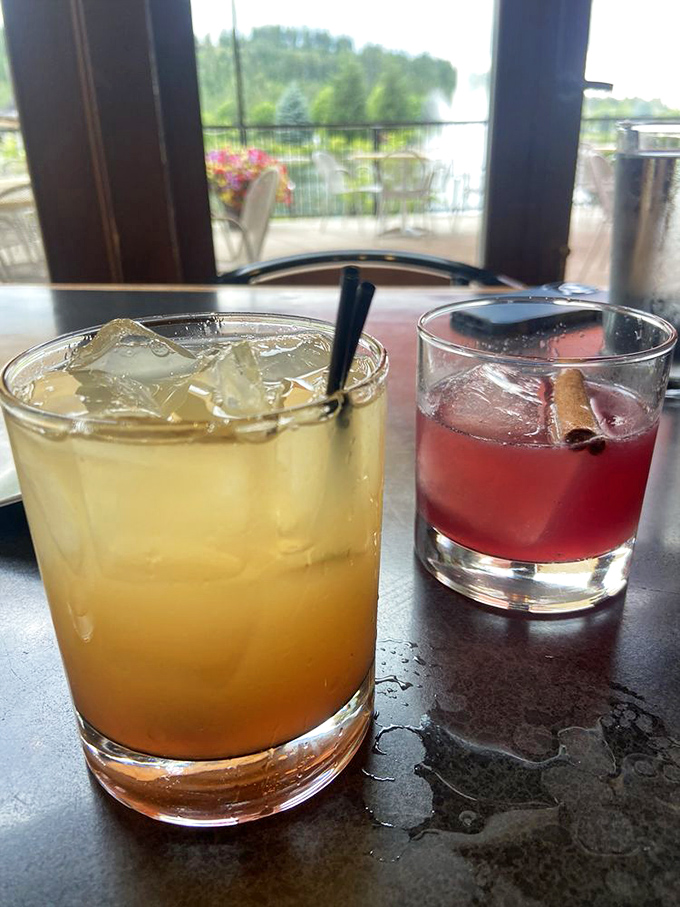 Cocktails with a view&mdash;liquid sunshine in a glass alongside what appears to be a classic negroni. The perfect companions for lakeside contemplation.
