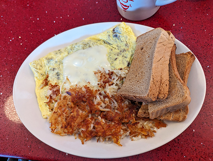 The omelet that launched a thousand satisfied sighs. Those crispy-edged hash browns deserve their own fan club and merchandise line.