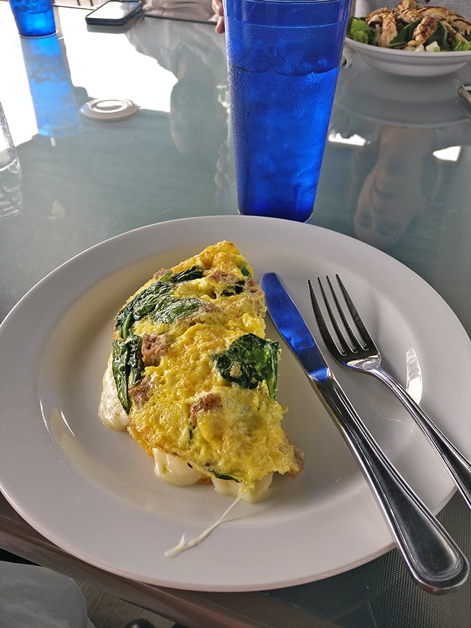 An omelet stuffed with greens and cheese that somehow manages to be both virtuous and indulgent. The blue cup adds dramatic effect.