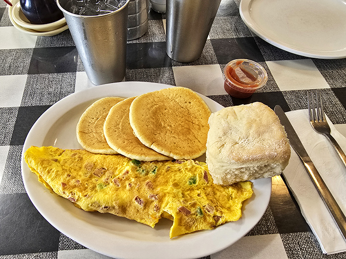 An omelet that clearly graduated with honors, flanked by pancakes that look like they're auditioning for a breakfast commercial.