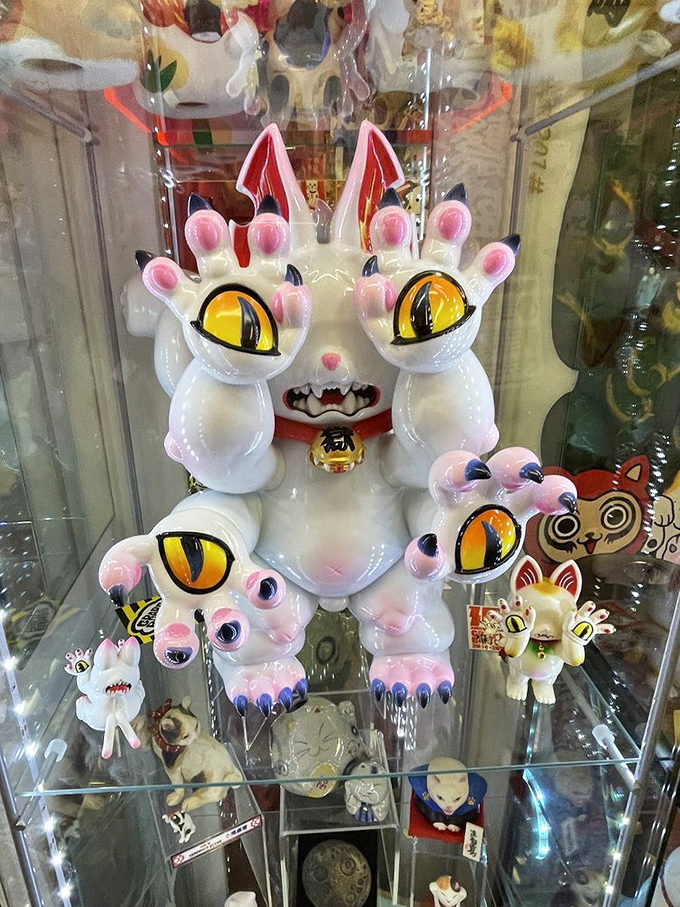 Not your average kitty! This multi-armed, yellow-eyed creature looks like what might happen if Hello Kitty had a cameo in a Guillermo del Toro film.