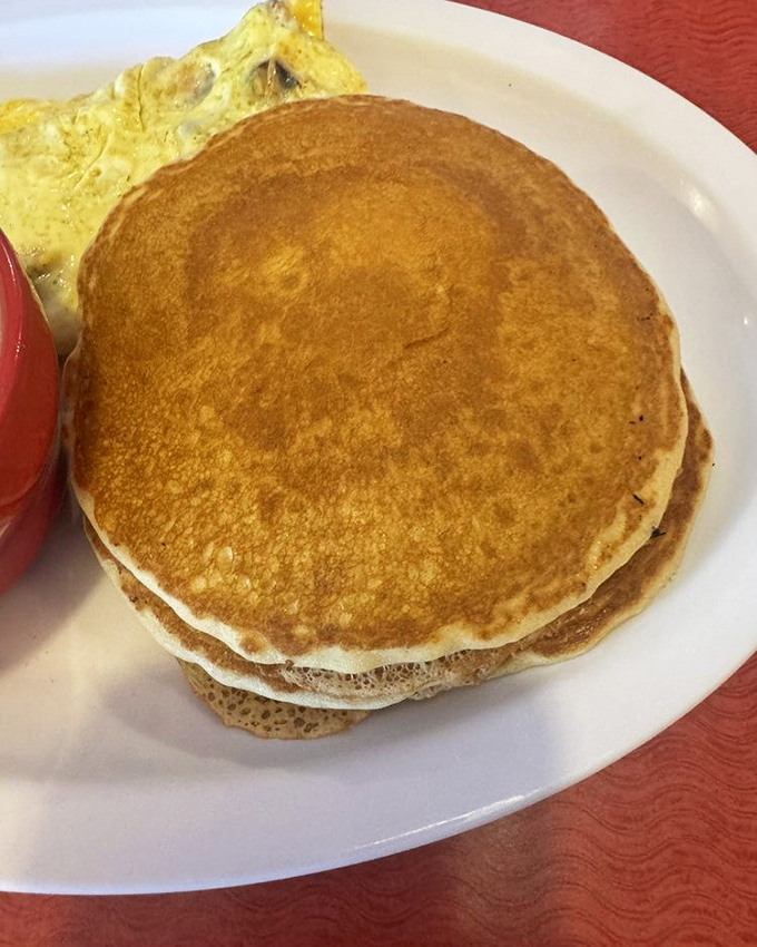 Golden pancakes stacked higher than your weekend expectations, ready for their maple syrup waterfall moment.