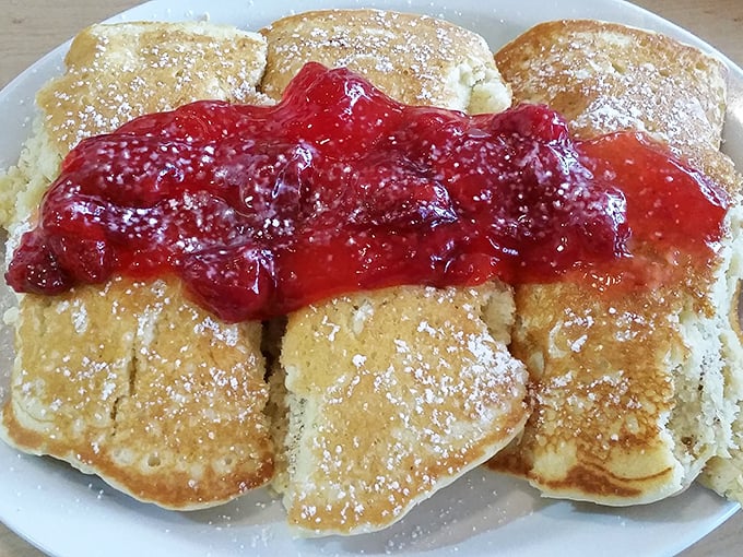 Pancakes wearing their strawberry topping like a crown. Breakfast royalty that doesn't stand on ceremony &ndash; just maple syrup.
