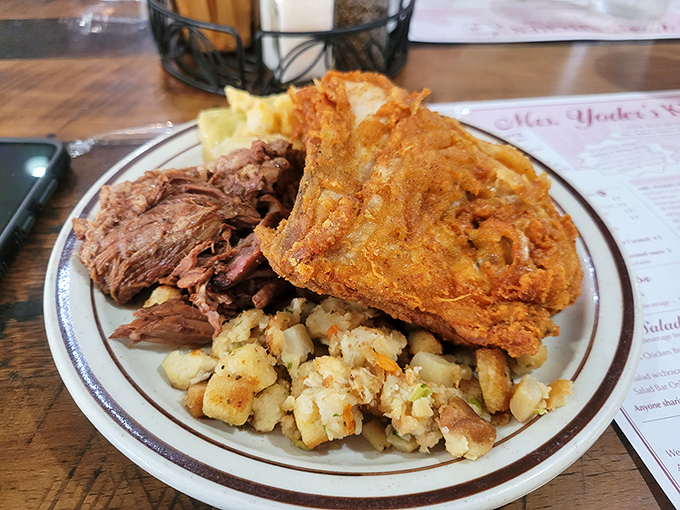 A buffet plate showcasing the holy trinity of comfort food: tender roast beef, crispy fried chicken, and homestyle stuffing. Diet plans, beware.