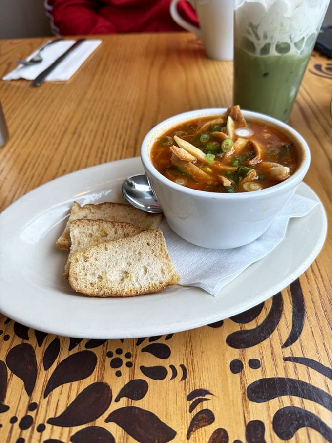 This isn't just soup&mdash;it's liquid comfort served with toast soldiers ready for dunking duty. Note the matcha latte photobombing in the background.