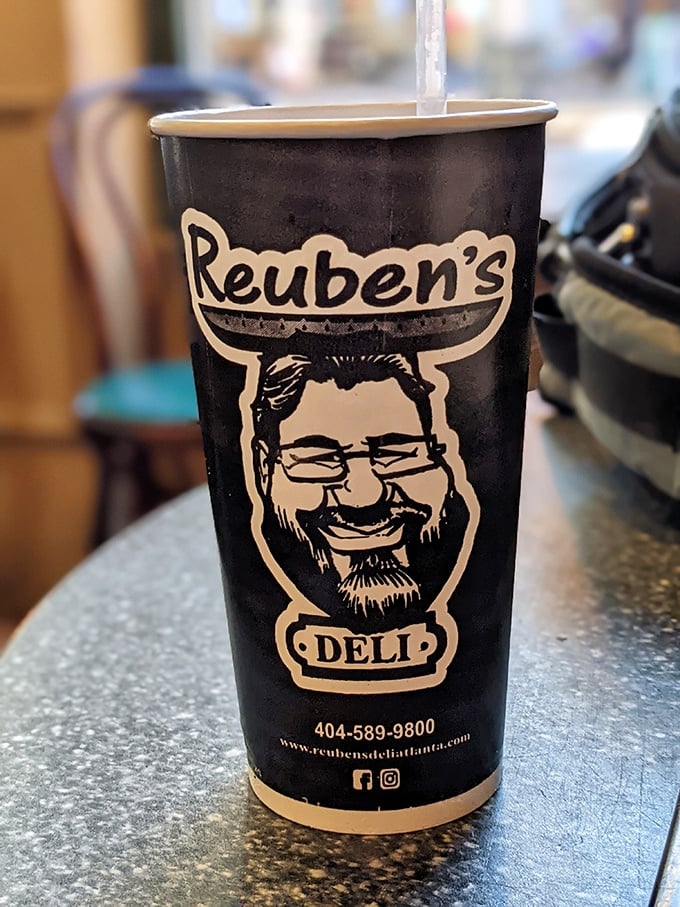 That cup isn't just holding coffee&mdash;it's carrying liquid motivation with the smiling face of deli satisfaction on its side.