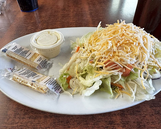The salad appears as a token gesture toward healthfulness, a mountain of shredded cheese saying, "We tried, but we know why you're really here."