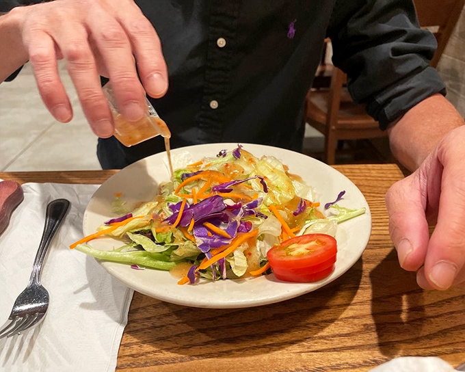 A fresh salad getting dressed tableside&mdash;proof that even in steak country, vegetables can have their moment in the spotlight.