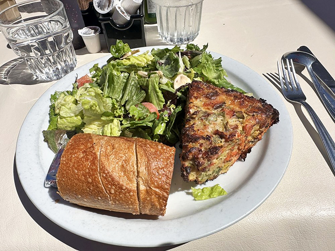 Quiche that stands tall and proud, flanked by a salad that's clearly not an afterthought but a worthy companion.