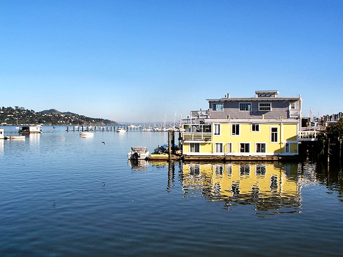 This sunshine-yellow houseboat reflects perfectly in Richardson Bay's calm waters, embodying Sausalito's free-spirited approach to waterfront living.