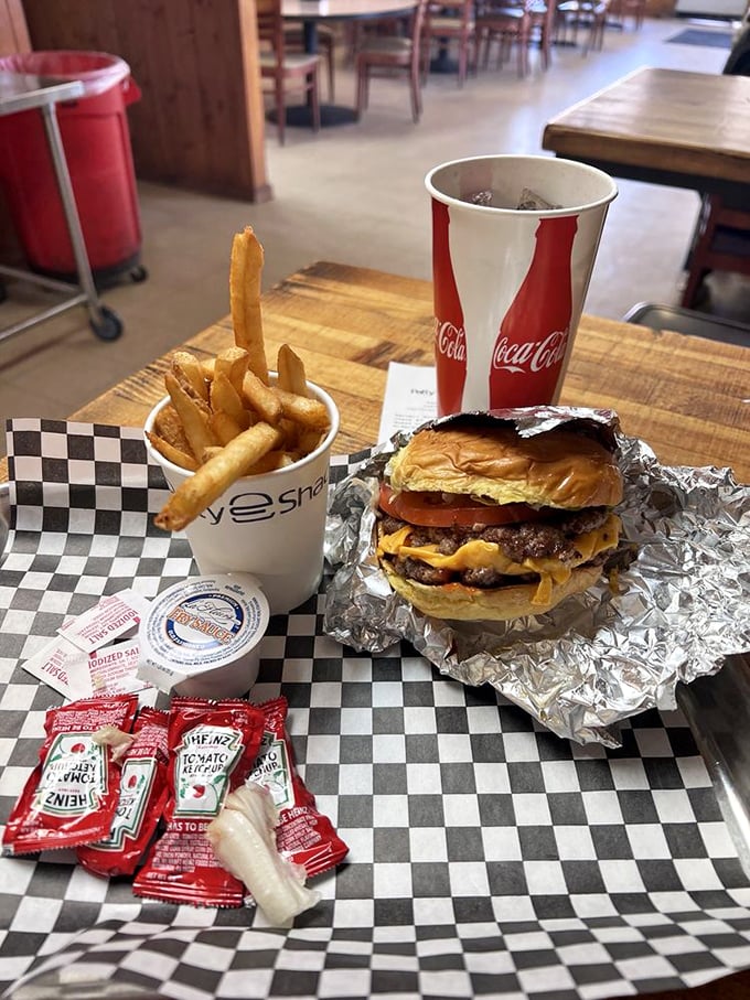 The holy trinity of comfort food: a perfect burger, golden fries, and an ice-cold drink. Simplicity at its most sublime.