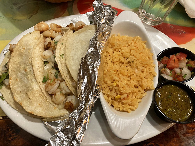 Shrimp tacos arrive like little edible presents, wrapped in soft tortillas alongside perfectly seasoned rice and fresh pico de gallo.