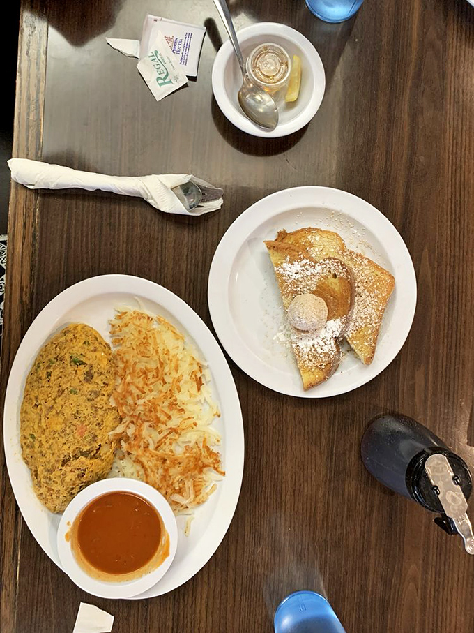 Breakfast table or artist's palette? This overhead view showcases the simple beauty of a well-executed omelet alongside perfectly crisped hash browns.