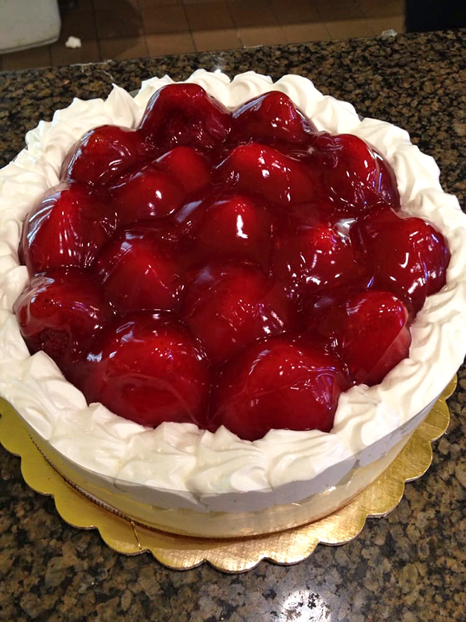 A strawberry cheesecake so gloriously red it could stop traffic. The whipped cream border stands guard like delicious sentinels protecting berry treasure.