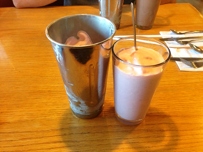 That milkshake moment when you realize happiness can indeed be sipped through a straw. Cold, creamy perfection on a wooden table.