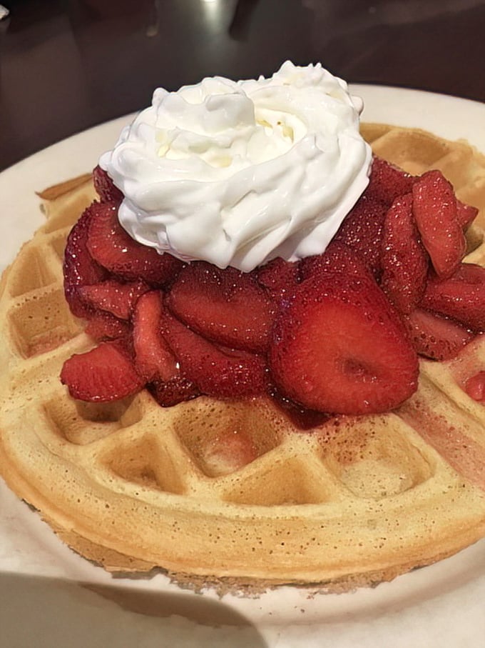 Fresh strawberries crown this golden waffle like nature's own dessert disguised as acceptable breakfast fare. 