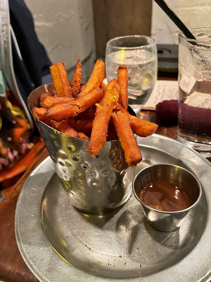 Sweet potato fries standing at attention in their metal holder, ready to be dipped in that mysterious sauce that you'll dream about later.