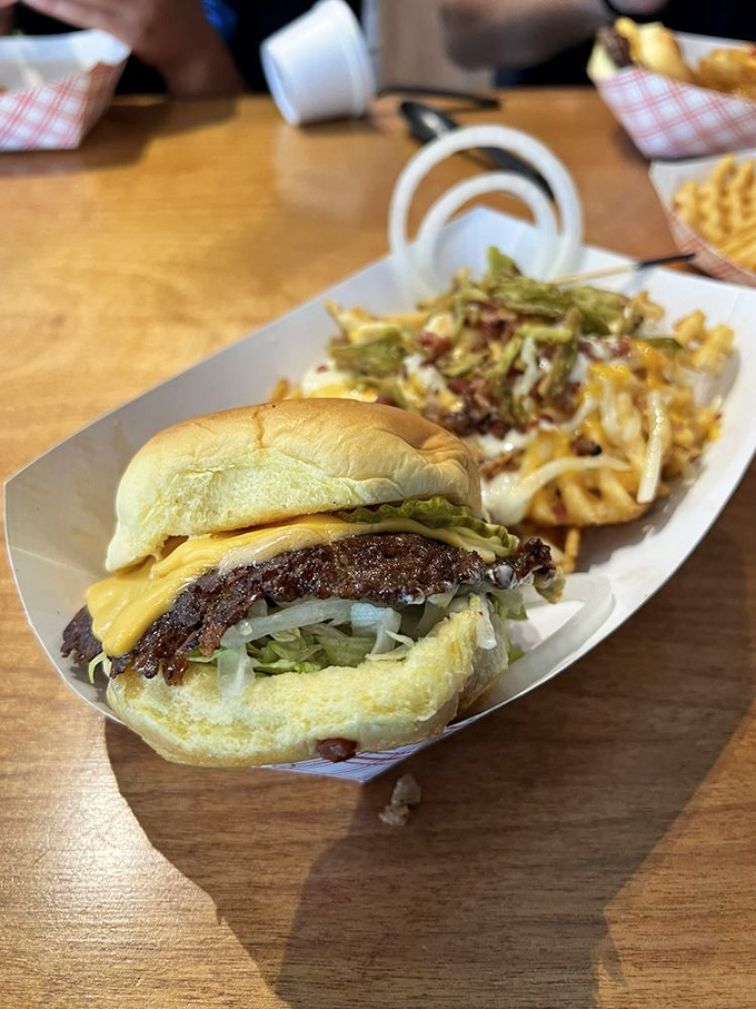 The original burger with its lacy-edged patty sits beside fries that gleam like they've been polished. This is the kind of plate that makes conversation stop mid-sentence.