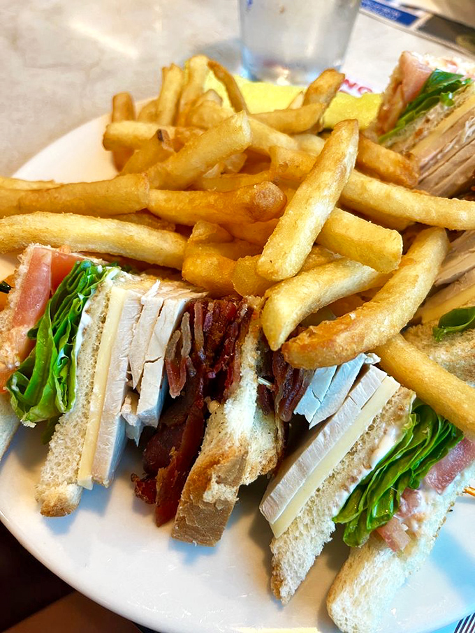 The club sandwich &ndash; that architectural marvel of diner cuisine. Layers of turkey, bacon, and fresh greens perfectly stacked between toasted bread triangles. A skyscraper of satisfaction.