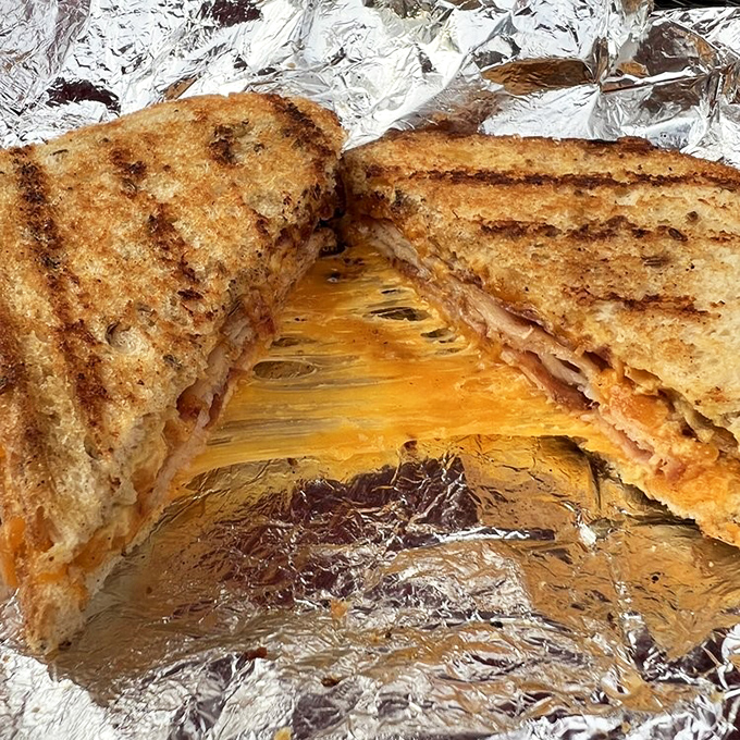 The Turkey Melt reveals itself in all its glory—where melted cheese meets toasted bread in that perfect union that makes everything right with the world.