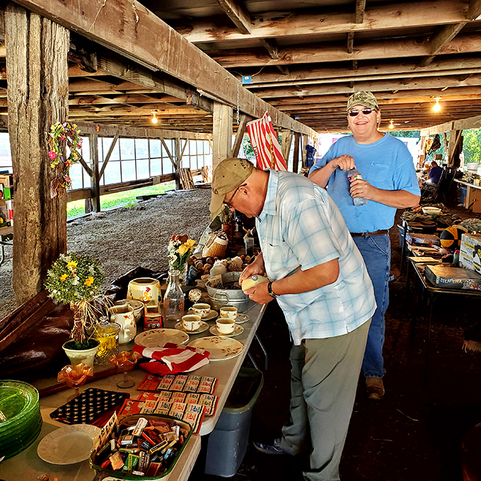 Inside a covered pavilion, shoppers examine vintage dishware and collectibles while vendors share stories about each piece's history and provenance.