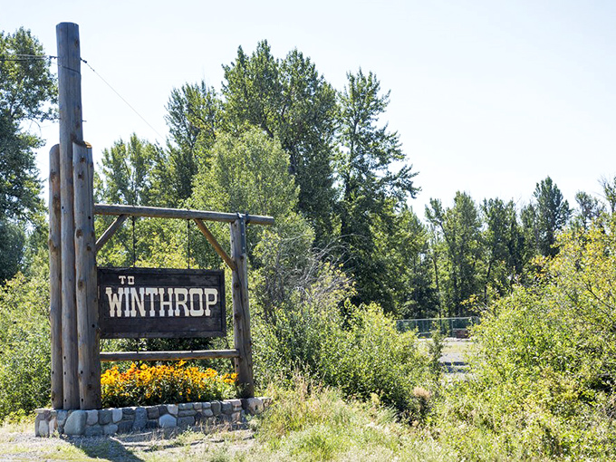 Nothing says "you've arrived" quite like Winthrop's rustic welcome sign, standing tall among wildflowers like a friendly frontier greeting card.