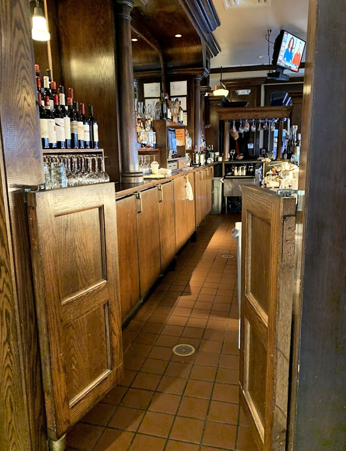 The bar area: where wood-paneled warmth meets Italian hospitality, and where "just one more glass" becomes the evening's unofficial motto.