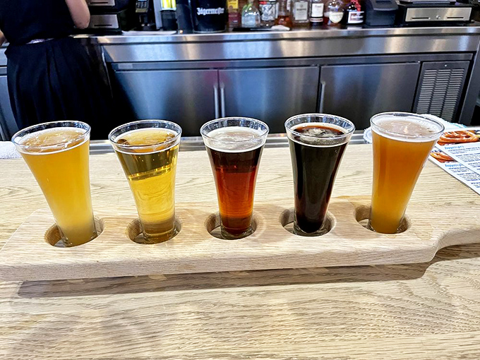 A wooden flight board showcasing liquid gold in five shades&mdash;from pale straw to midnight amber. Each glass tells a different centuries-old brewing story.