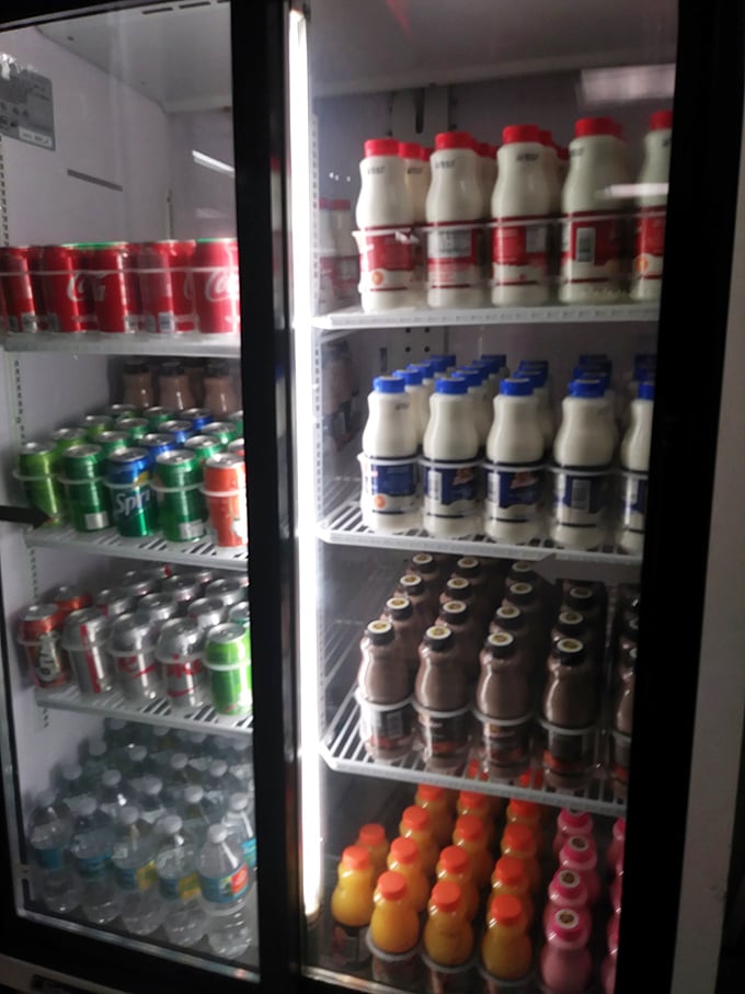 The refrigerator case offers liquid companions for your donut adventure. Because even sweet perfection needs something to wash it down.