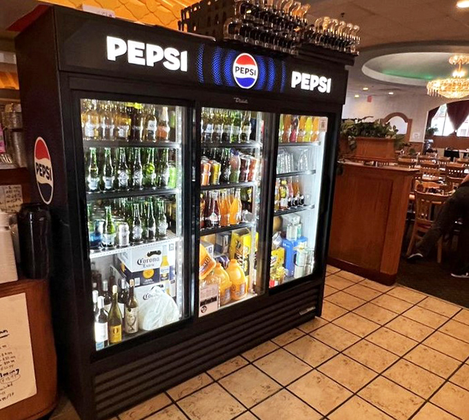 The beverage cooler – because washing down five plates of food requires options. It's like a liquid United Nations of refreshment possibilities.