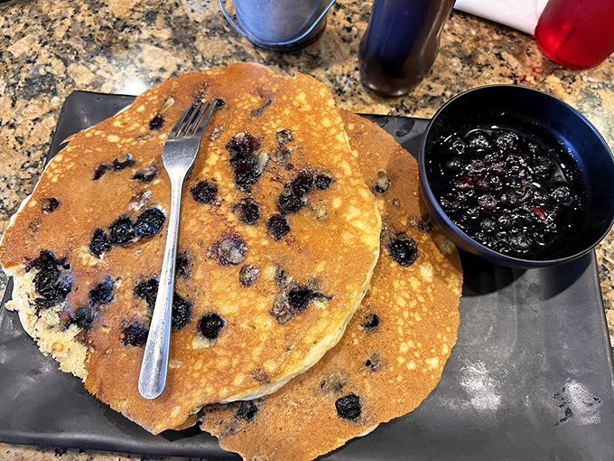 Blueberry pancakes that look like they're auditioning for a breakfast commercial – golden, studded with berries, and served with a side of pure happiness.
