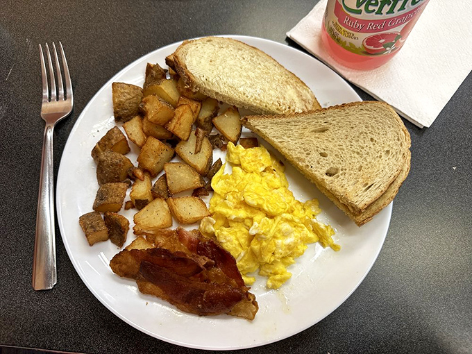 The breakfast trinity: fluffy scrambled eggs, crispy home fries, and toast ready for its butter bath. Simple pleasures executed flawlessly.