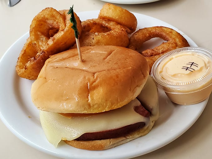 The classic cheeseburger and onion rings combo&mdash;proof that sometimes the simplest pleasures are the most profound. Nostalgic deliciousness on a white plate.
