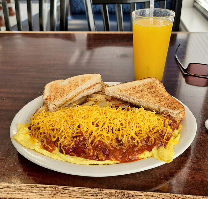 This omelet has clearly been working out&mdash;bulging with chili and topped with enough cheese to make Wisconsin proud. The toast stands guard, ready for cleanup duty.