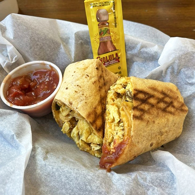 Breakfast burrito brilliance wrapped in tortilla engineering. Chorizo and eggs find their perfect home alongside that essential bottle of hot sauce.